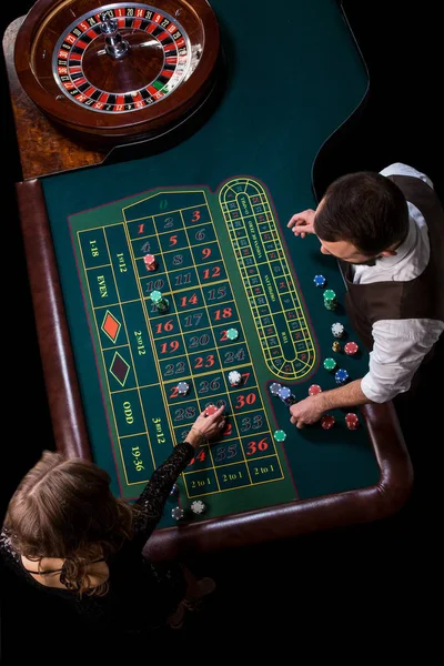 Croupier and woman player at a table in a casino. Picture of a c ...