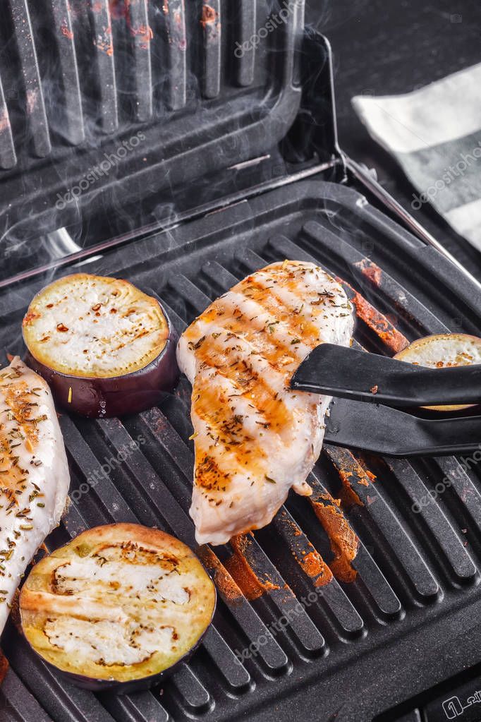 El humo se eleva sobre el filete de pechuga de pollo y berenjenas ...