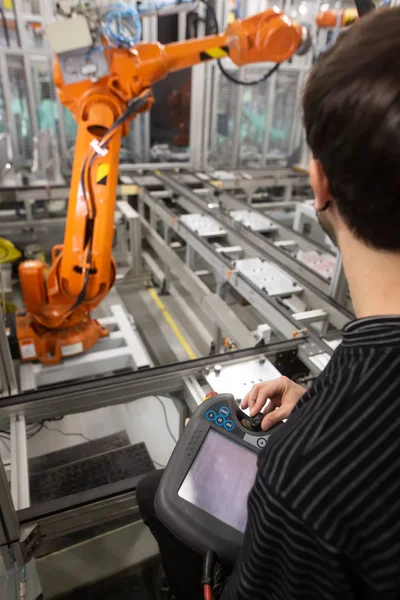 Man programming robot in automotive industrial, professional programmer ...