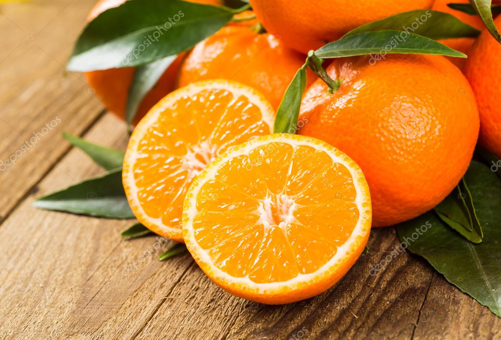 Ripe Mandarin fruit peeled open and place on old rustic look tim Stock ...