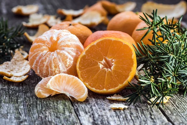 Ripe Mandarin fruit peeled open and place on old rustic look tim ...