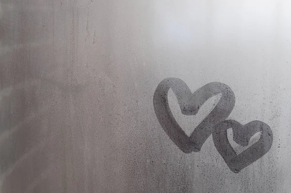 Couple of abstract blurred love heart symbol drawn by hand on the wet ...