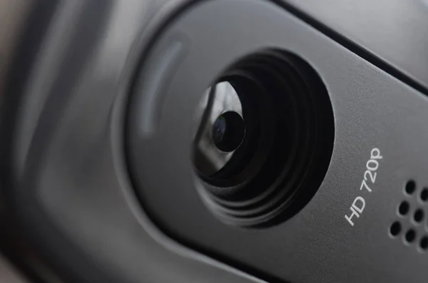 A modern web camera is installed on the body of a flat screen monitor ...