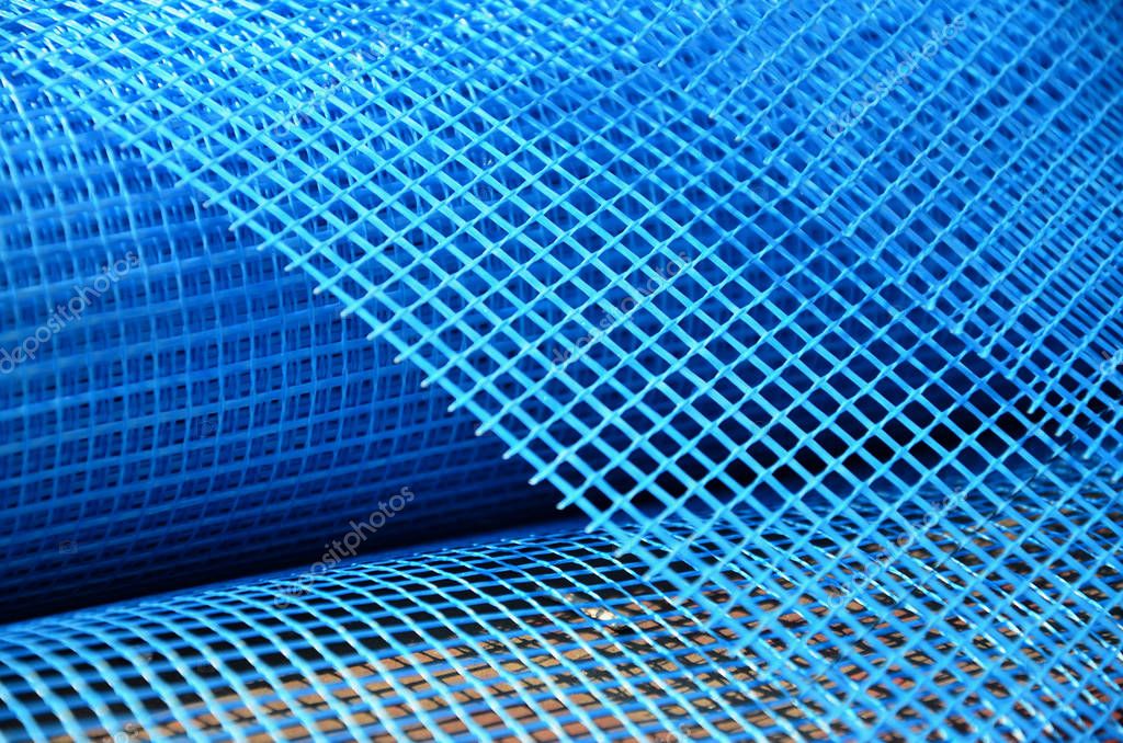 Textura de primer plano de una malla de refuerzo azul enrollada en un ...
