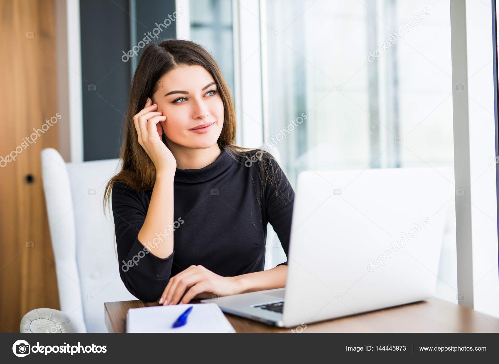 Young pretty business woman with notebook in the bright modern office ... Young pretty business woman with notebook in the bright modern office ...