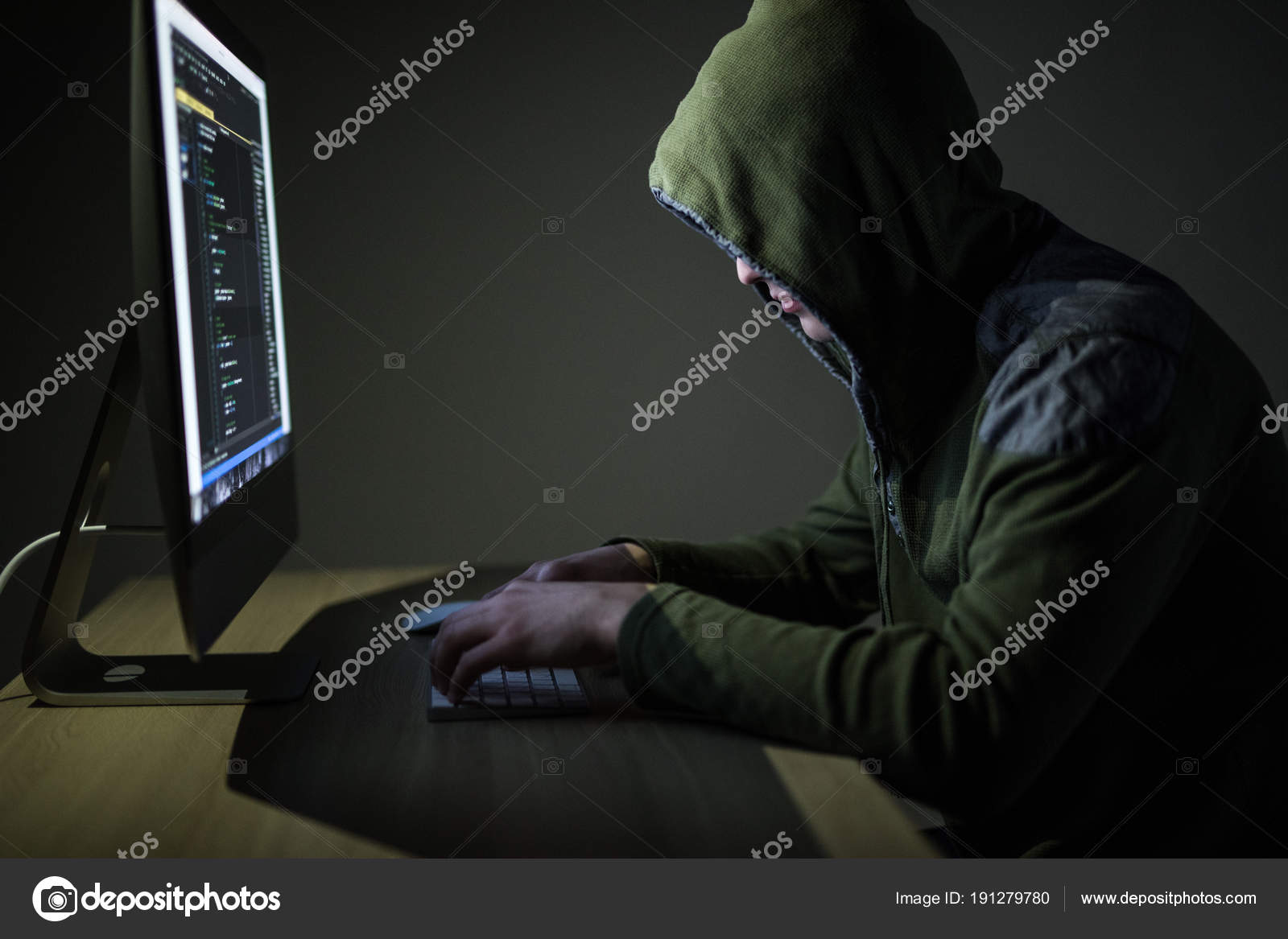 Hooded computer hacker stealing information with pc in Dark room ...