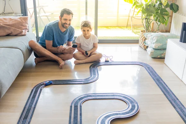 Father and son playing car races at home - Stock Image - Everypixel
