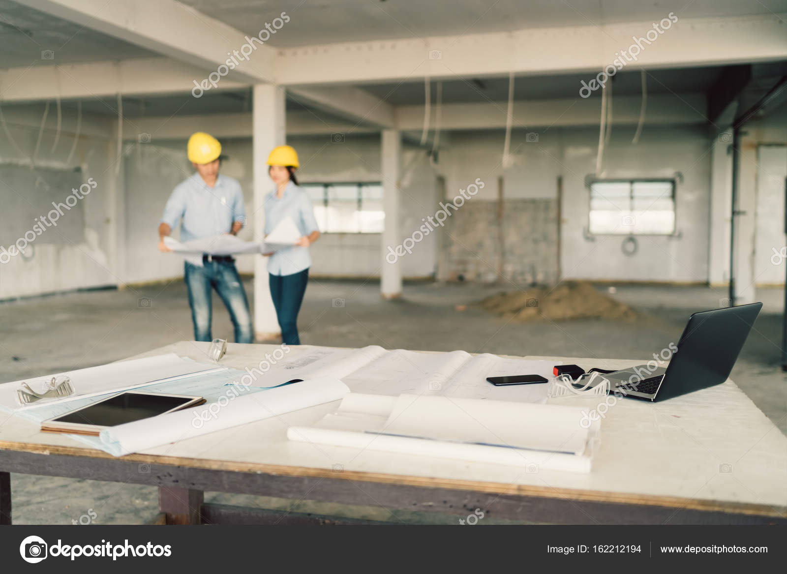 Blueprint, laptop computer, and industrial tools at construction site ...