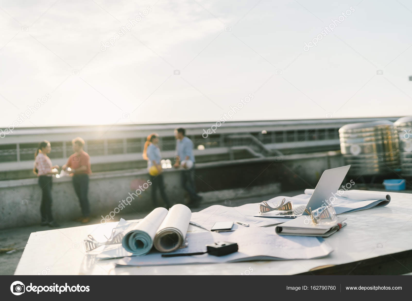 Engineers or architects relaxing after work at construction site. Focus ...