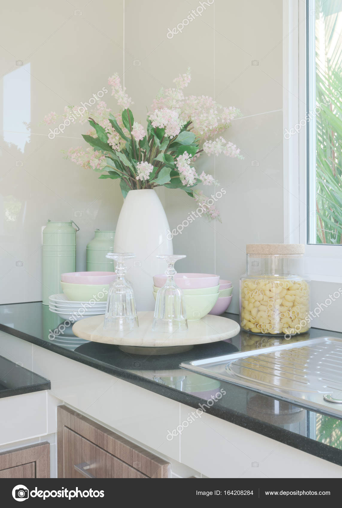 Ceramic kitchenware and flower vase on black counter top in the kitchen ...