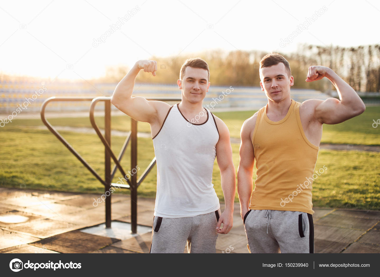 Two man stand at stadium with sunset background Stock Photo by ...