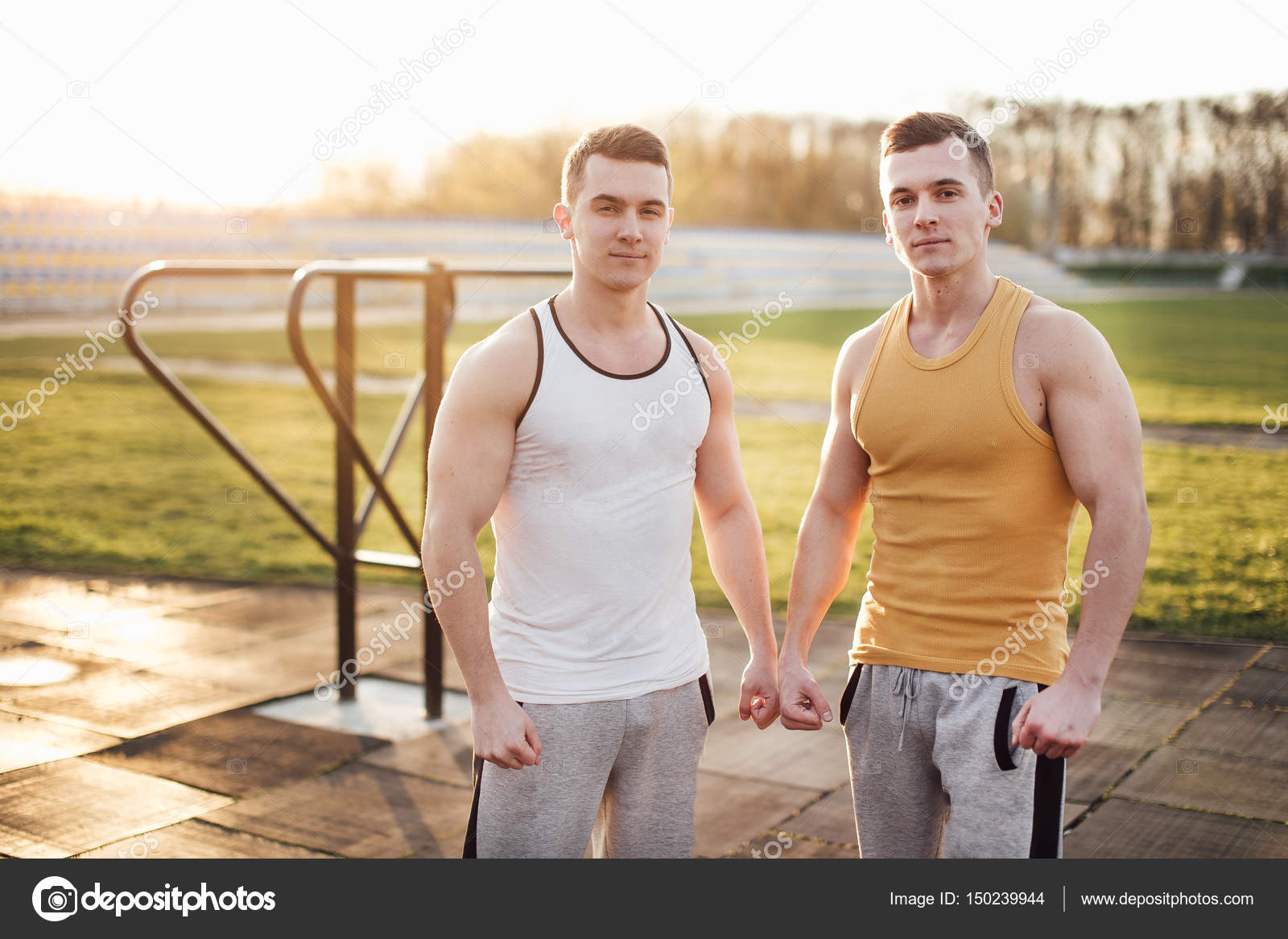 Two man stand at stadium with sunset background Stock Photo by ...