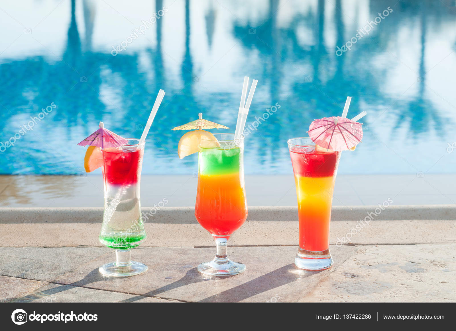 Colored cocktails on a background of water. Colorful cocktails near the ...