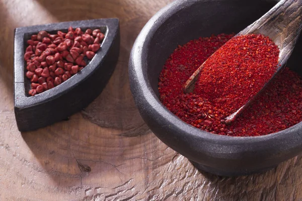 Achiote grains and powder in wooden bowl Stock Photo by ©CUNDO 160922730