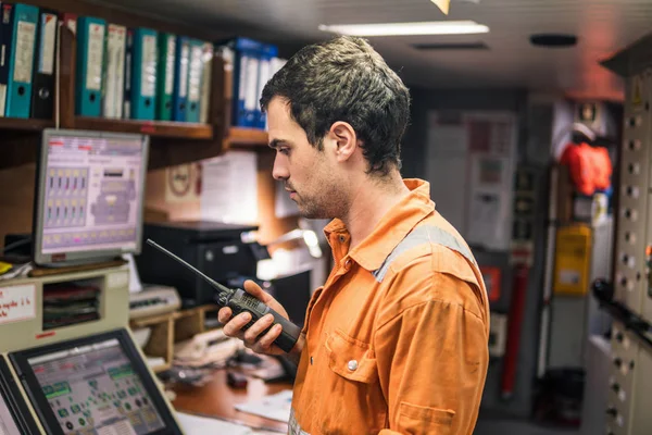 Marine Engineer working on radio communication at Engine Control room ...