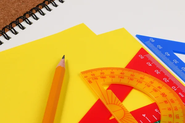 Drawing angles with set squares, pen, notebook and paper on plywood ...