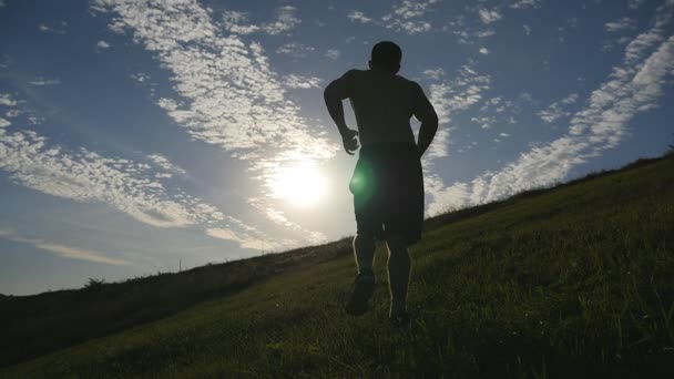 Young man running over green hill over blue sky background. Male ...