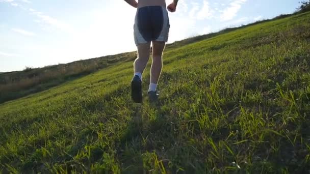 Young man running over green hill over blue sky background. Male ...