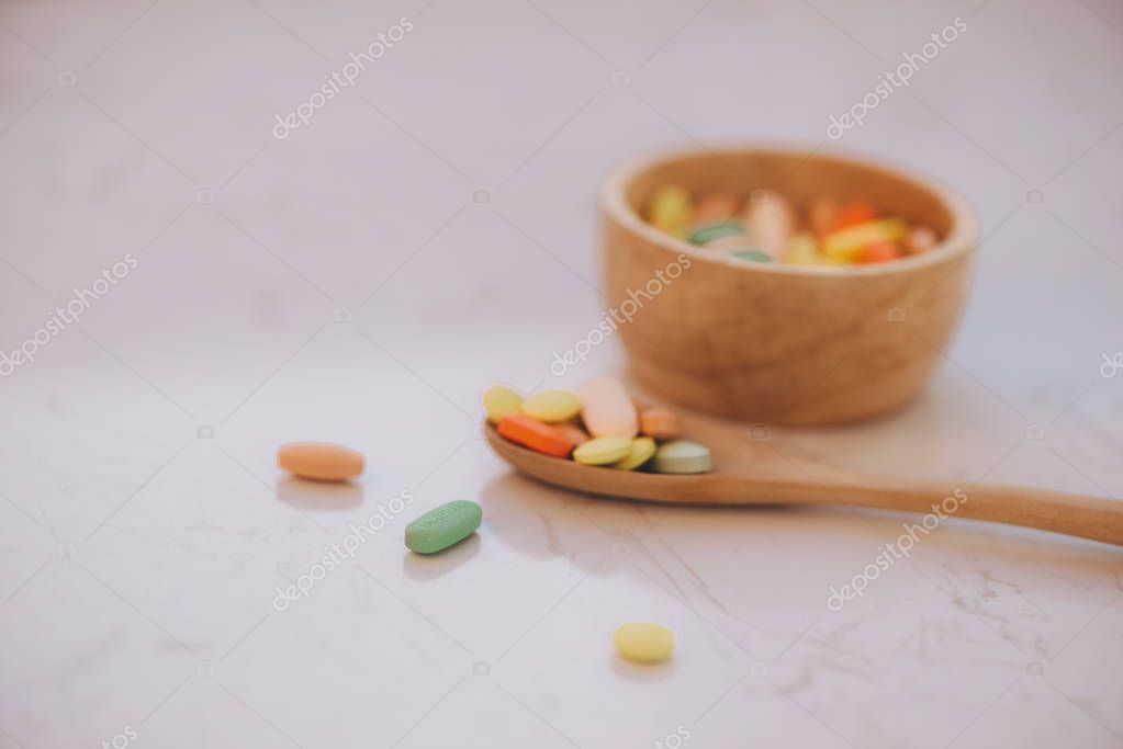 Surtido de p ldoras de medicamentos farmac uticos, tabletas y c psulas en cuenco de madera y ...