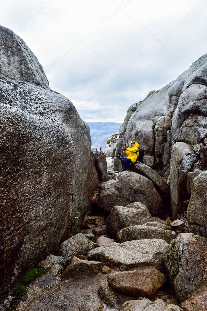 El turista fotografía un sendero hacia el Kjeragbolten es la piedra más peligrosa del mundo. La ...