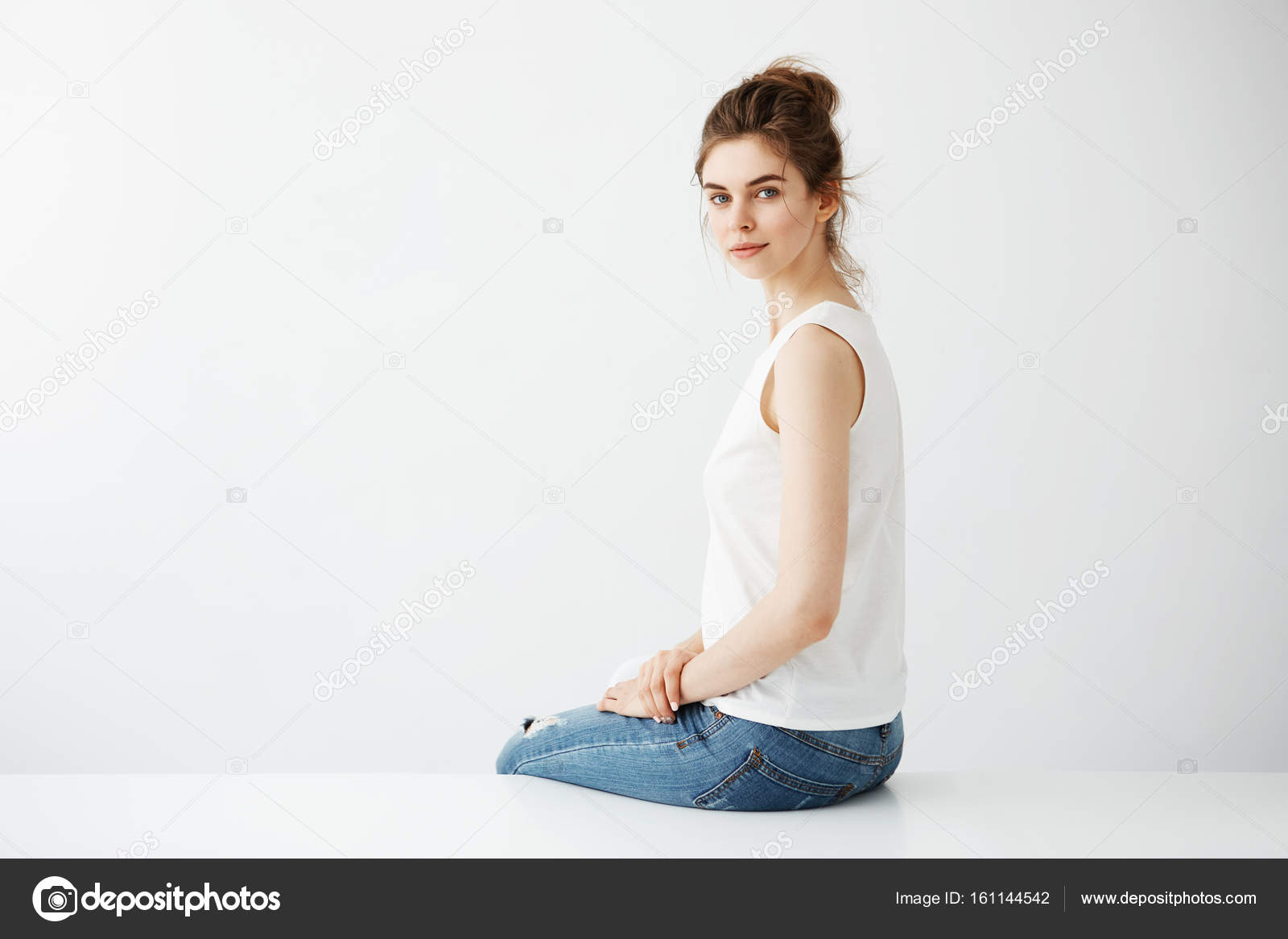 Young beautiful brunette girl with bun smiling looking at camera ... Young beautiful brunette girl with bun smiling looking at camera ...