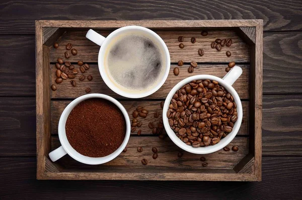 Different types of coffee - ground, grain and beverage on dark wooden ...