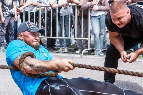 Strong man pulling heavy truck with a rope — Stock Editorial Photo ...