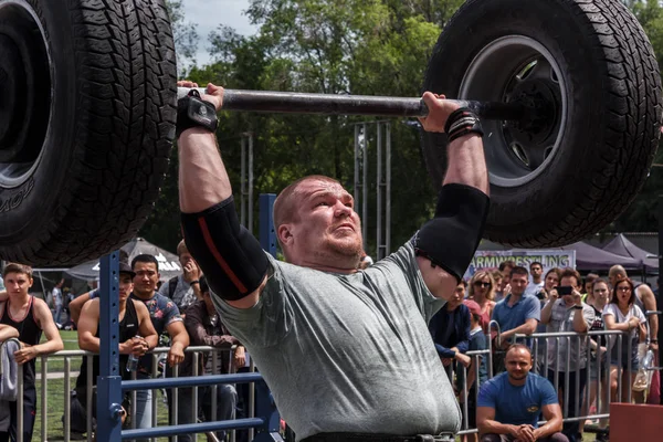 Strong man pulling heavy truck with a rope — Stock Editorial Photo ...
