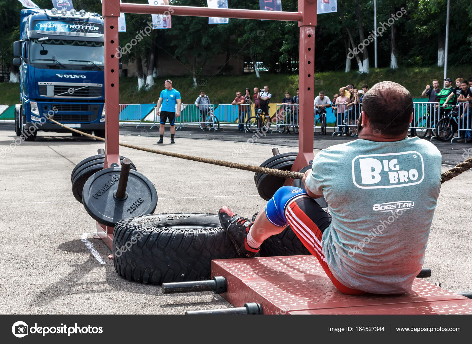Strong man pulling heavy truck with a rope — Stock Editorial Photo ...