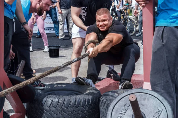 Strong man pulling heavy truck with a rope — Stock Editorial Photo ...