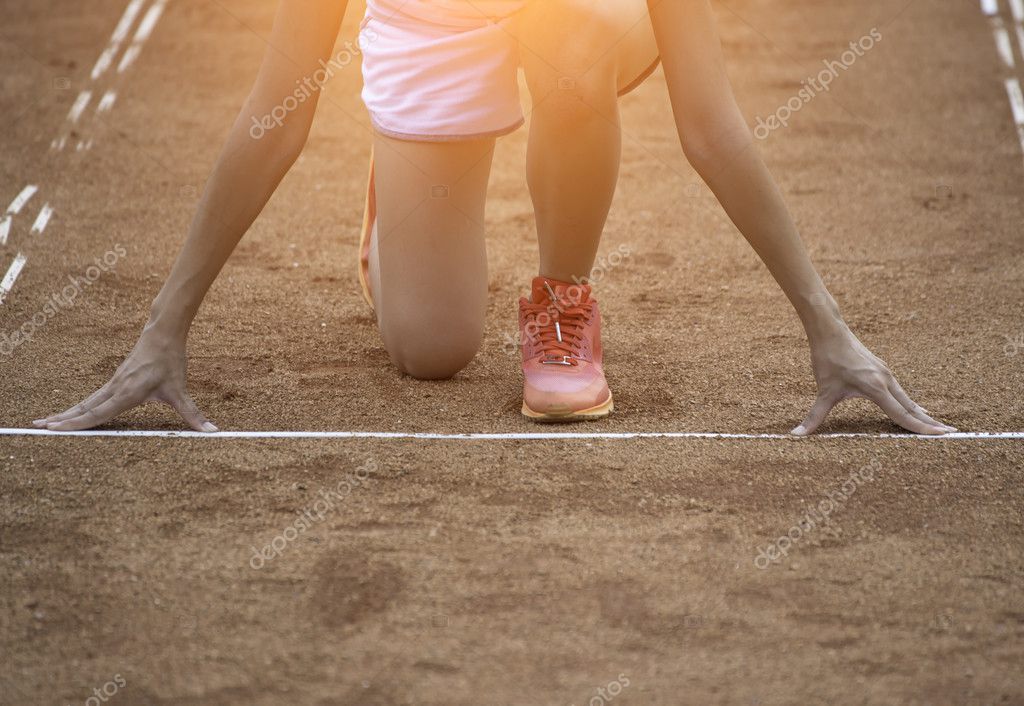 Corredores pies en los bloques de partida en una pista de atletismo 2024
