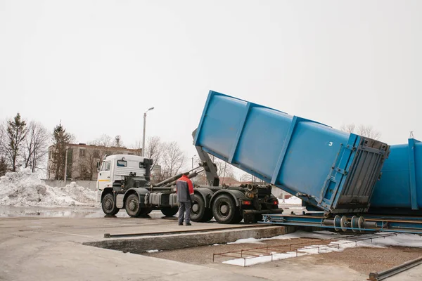 Loading container with waste to a special machine for subsequent ...