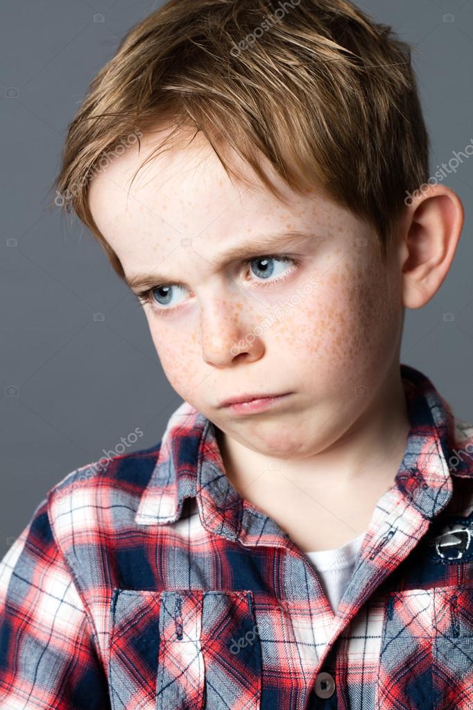 Disappointed little child with sad eyes and freckles for resignation ...