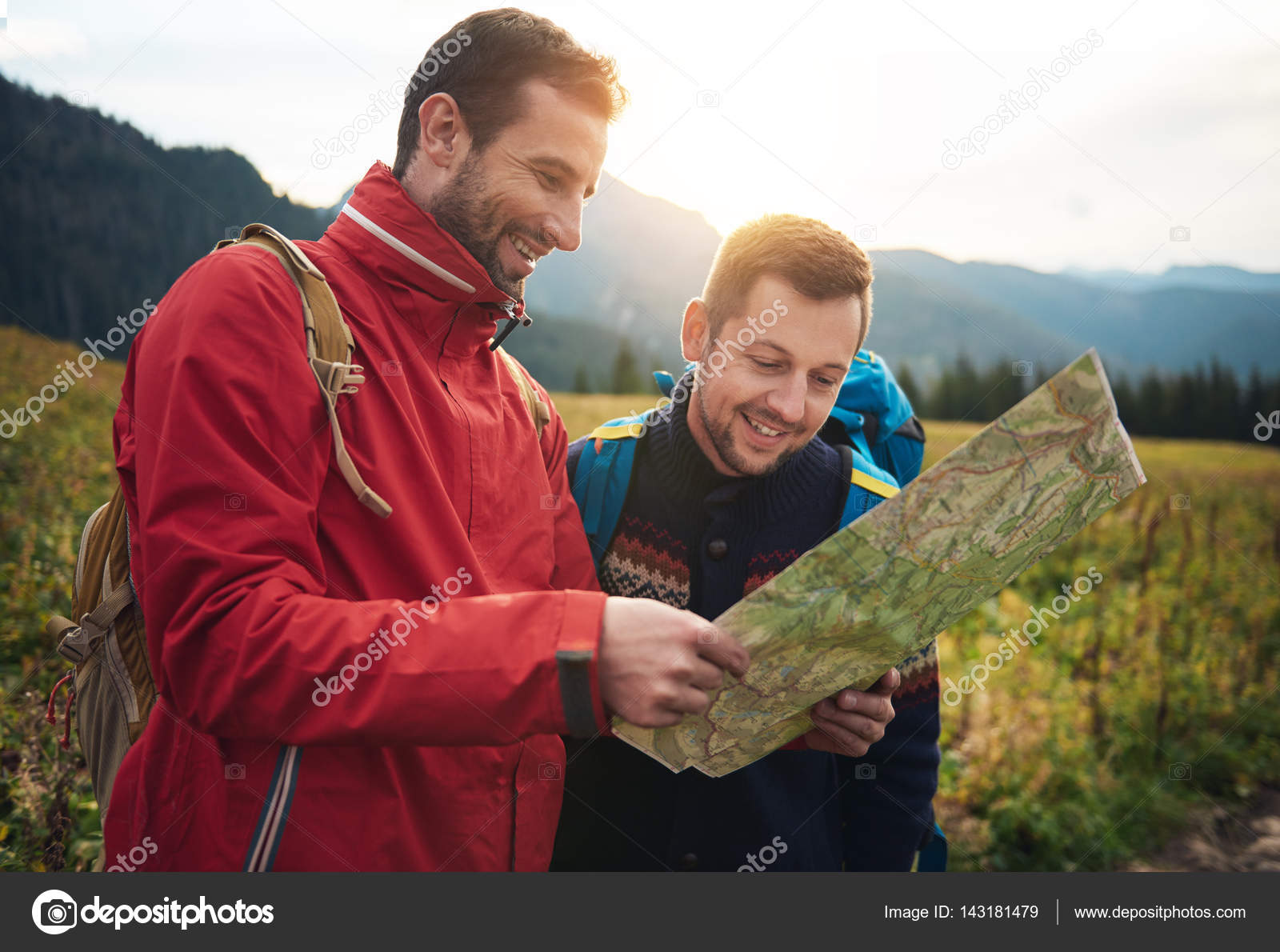 Smiling men reading trail map Stock Photo by ©mavoimages 143181479