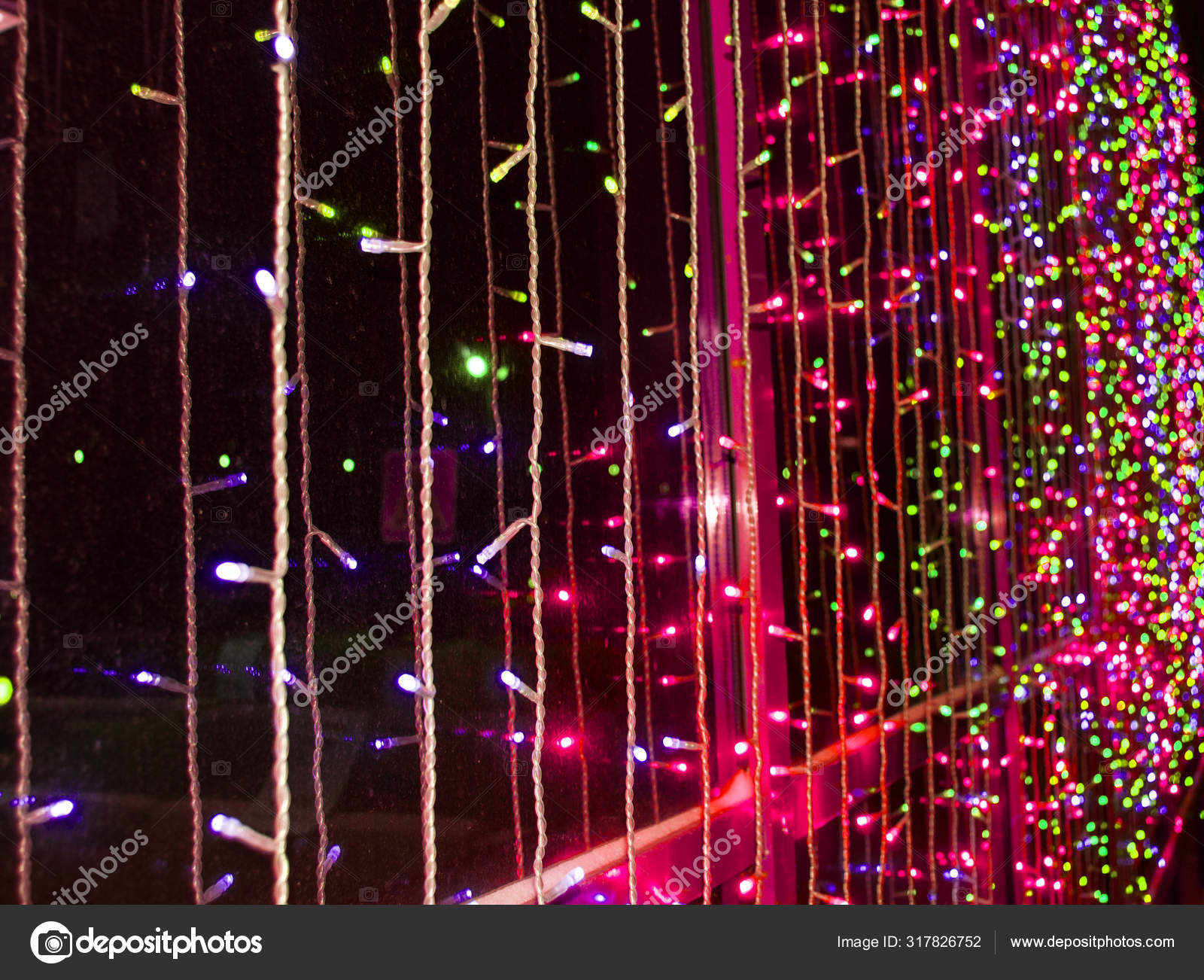 Multi-colored and red led lights on the building during the holiday ...