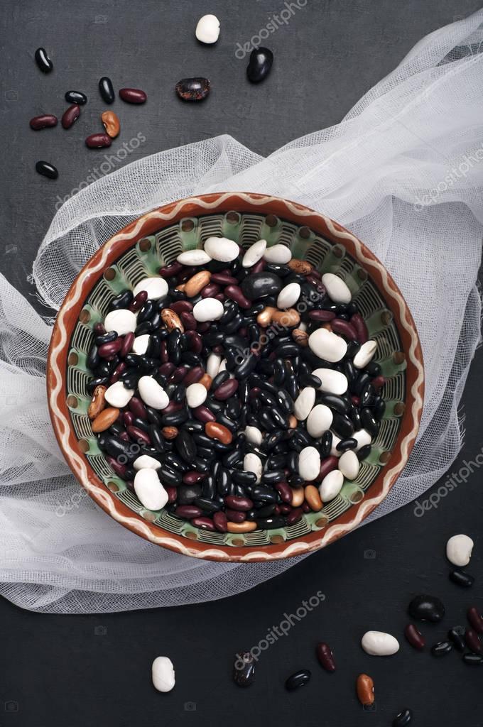Granos de frijol de diferentes colores en una placa de cerámica vintage ...