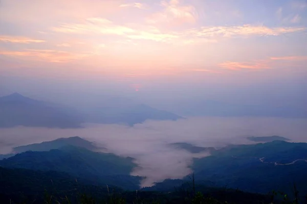 Morning mountain landscape with wave of fog on the top of mounta ...
