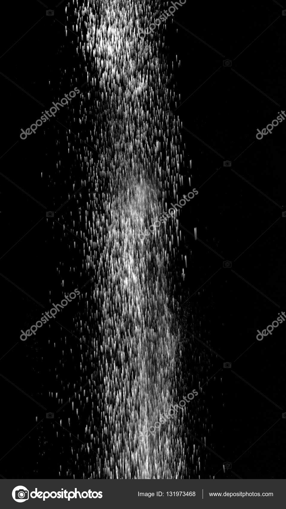 White powder falling, isolated on black, dark background. Abstract ...
