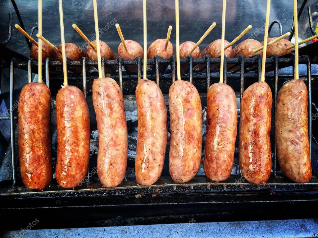 Embutidos fritos con ajo, hierbas y papas fritas en una sartén 2022