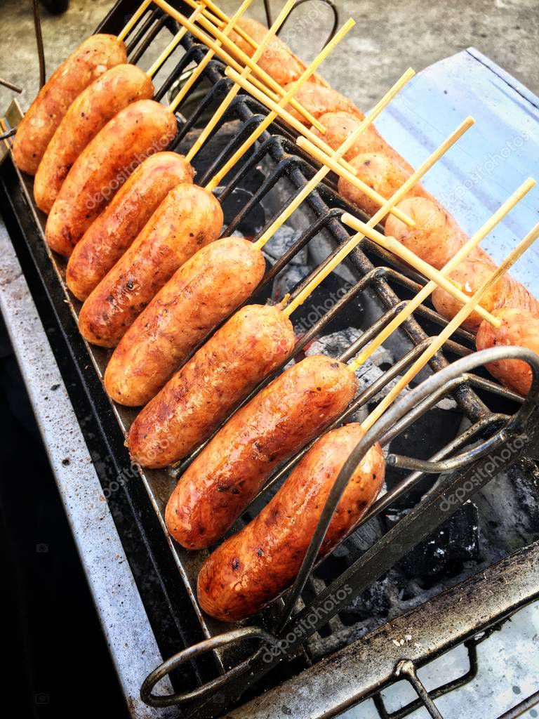 Embutidos fritos con ajo, hierbas y papas fritas en una sartén 2022