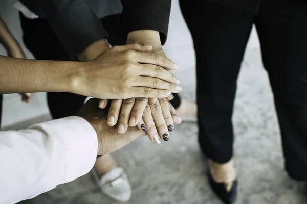 Close up of young business people putting and join their hands together ...