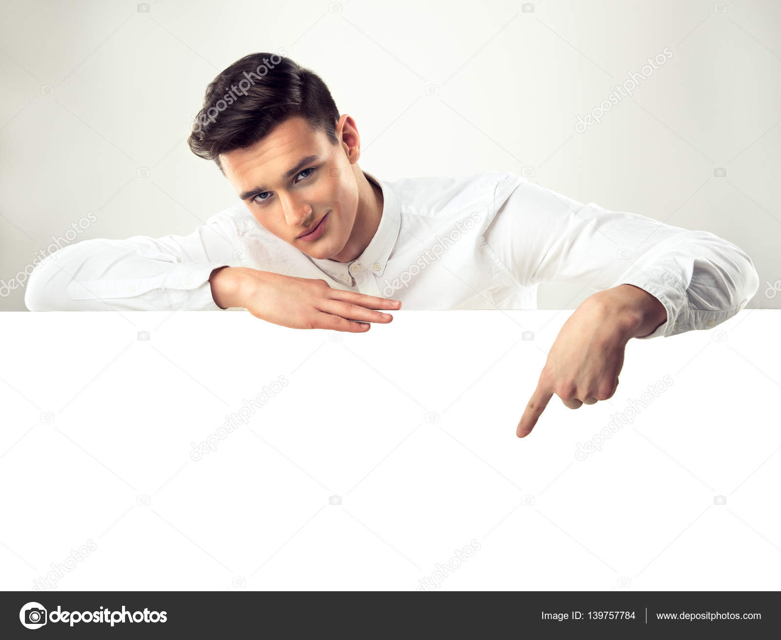 Young man points a finger down — Stock Photo © Sofia_Zhuravets #139757784
