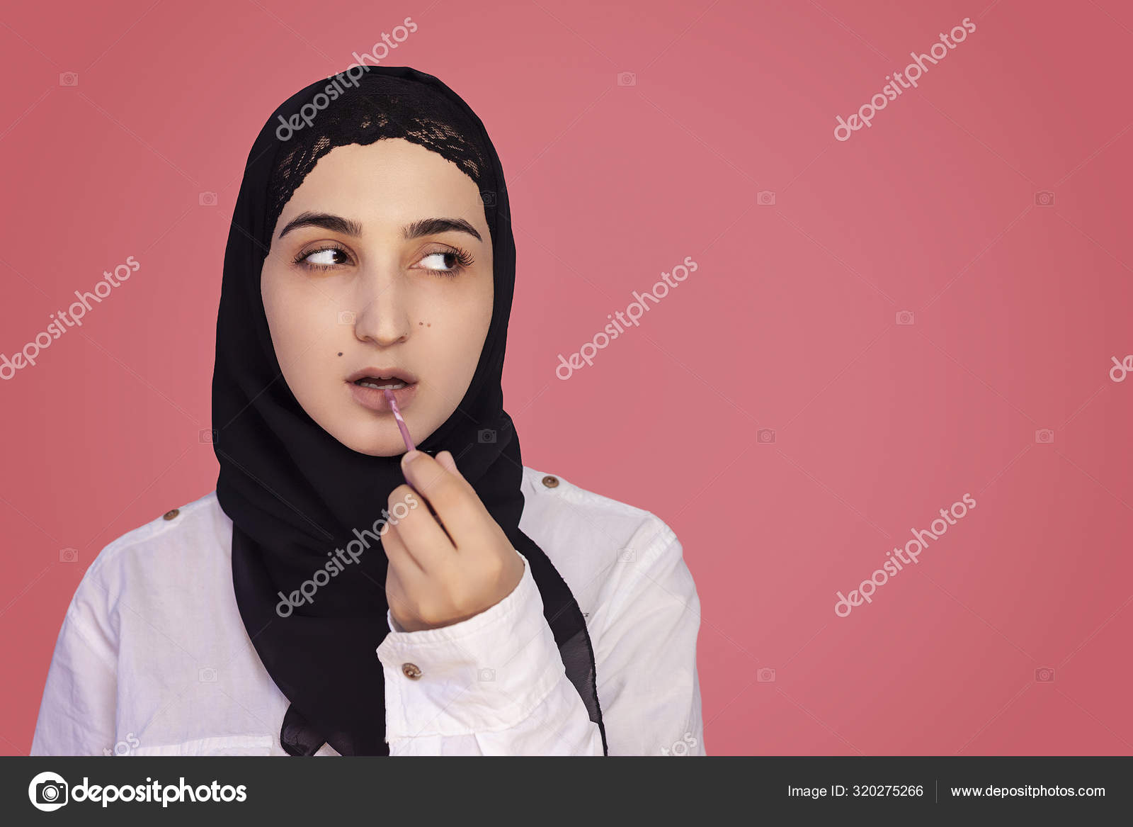 Cute 20s female putting lipstick with a brush. Beautiful Persian woman ...