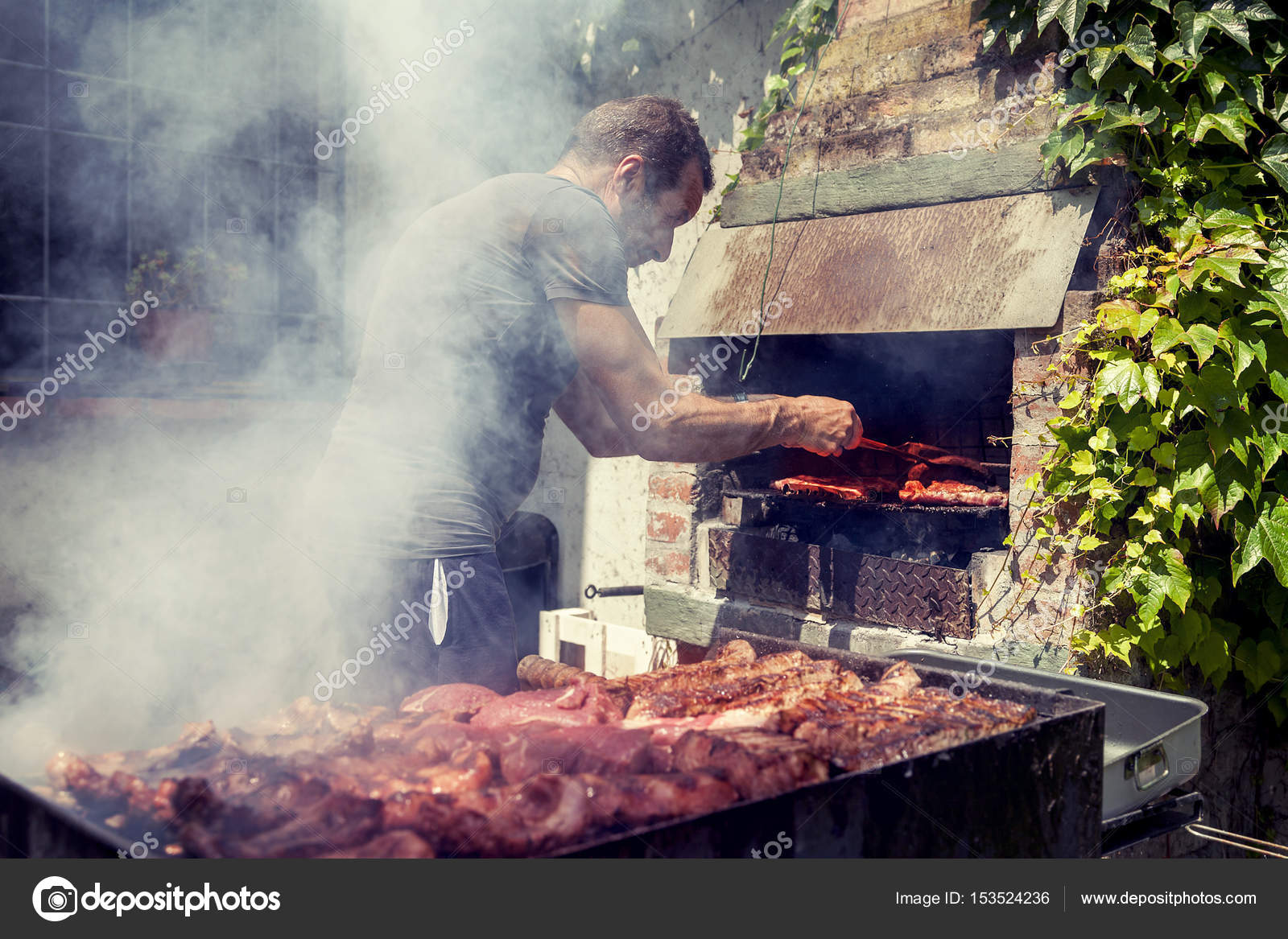 Handsome man preparing grilled meat for friends outdoor Stock Photo by ...