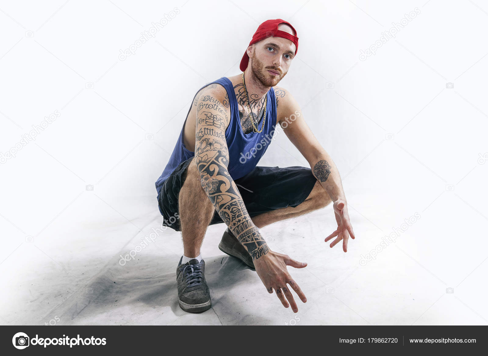 Sitting tattooed rap singer posing in studio Stock Photo by ...