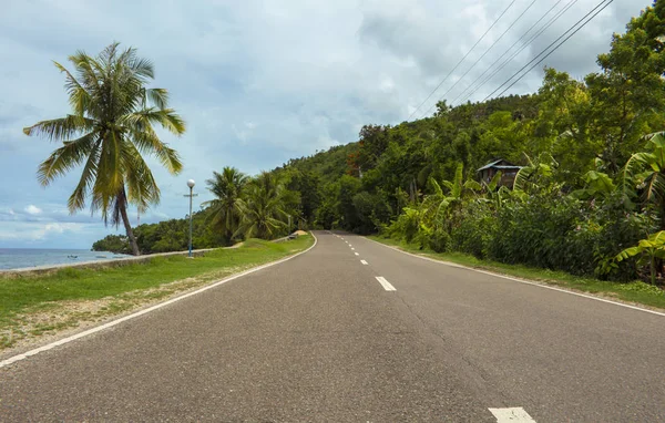Highway on tropical island. Coastal road in the afternoon. Empty road ...