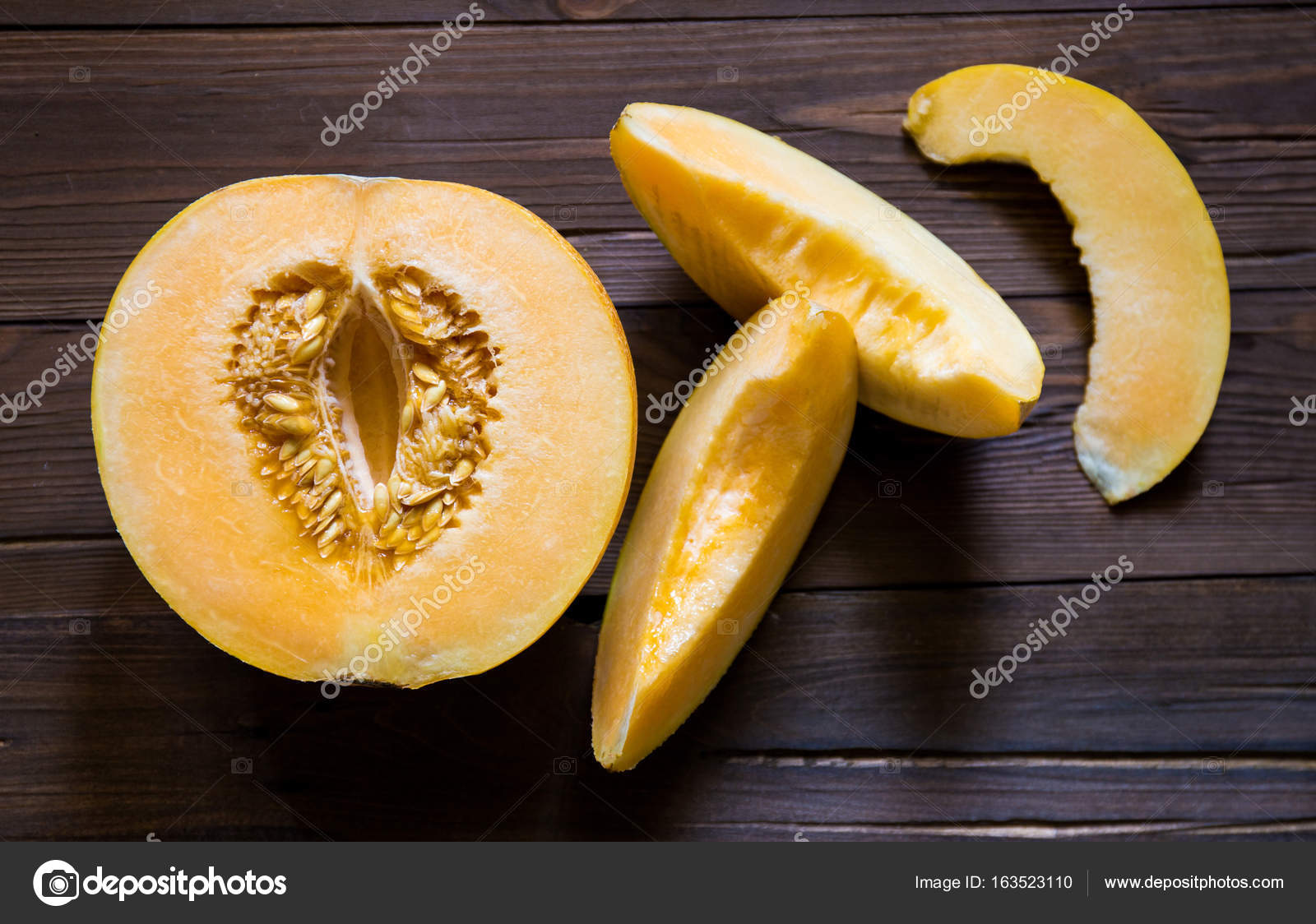 Half melon and slices on a dark wooden background Stock Photo by ...