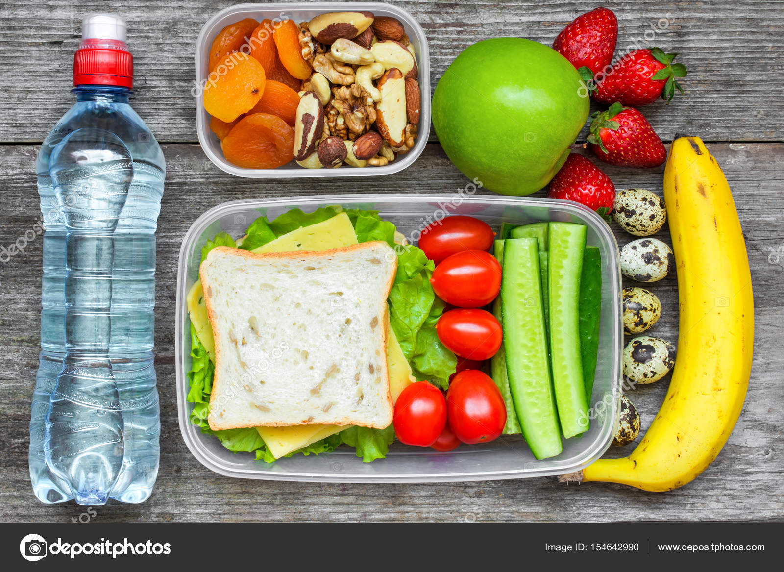 Healthy lunch boxes with sandwich, eggs and fresh vegetables, bottle of ...