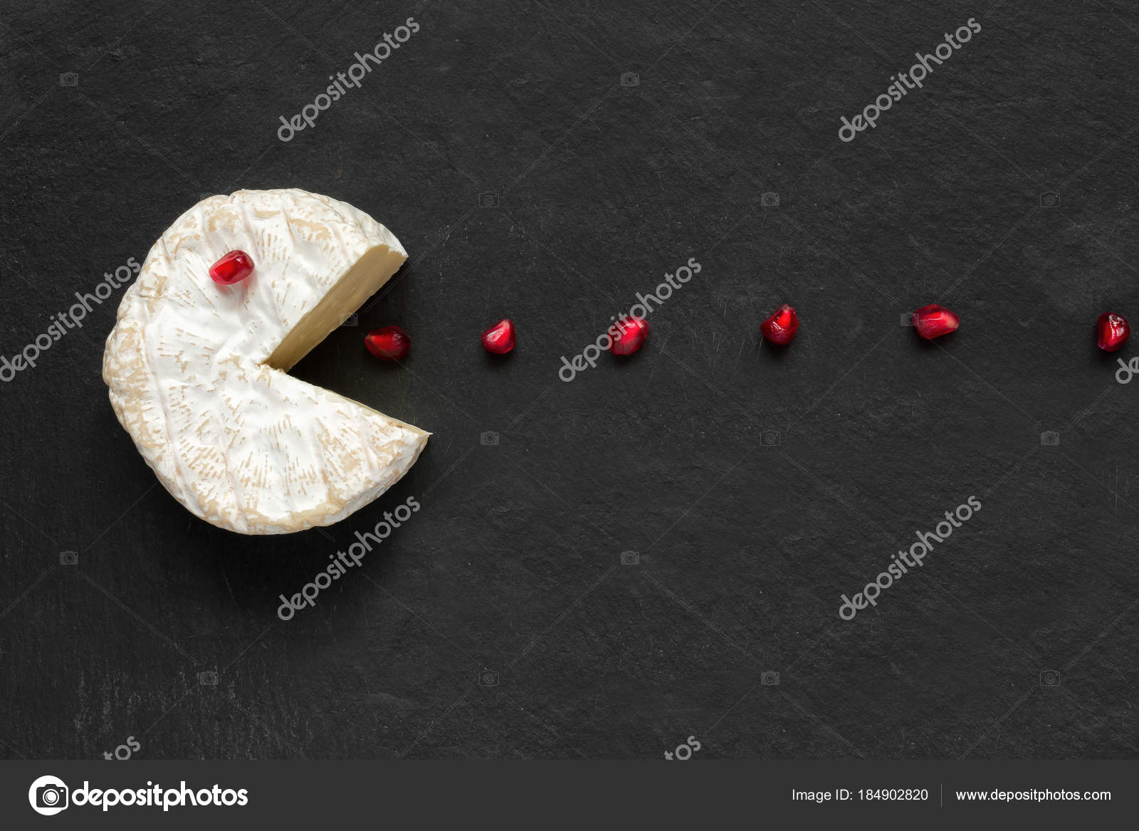 Camembert or brie cheese cut out like pacman eating pomegranate seeds ...