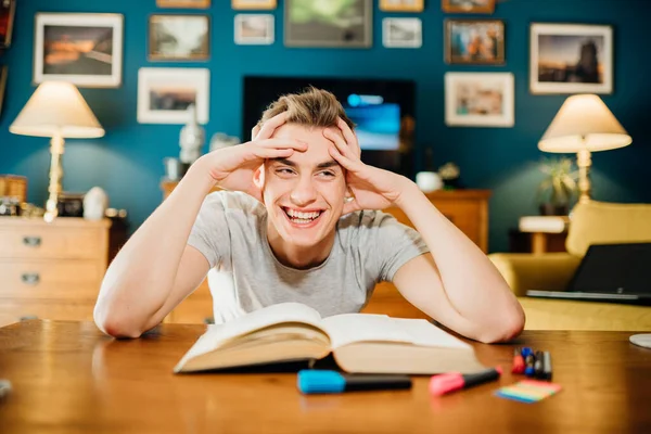 Smiling man studying from home.Bored student studying for exams.Student ...